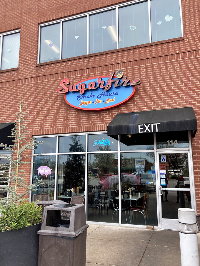 The brick-and-mortar temple of smoke beckons with its cheerful blue sign and red neon "BARBECUE" promise—a siren call to hungry travelers.
