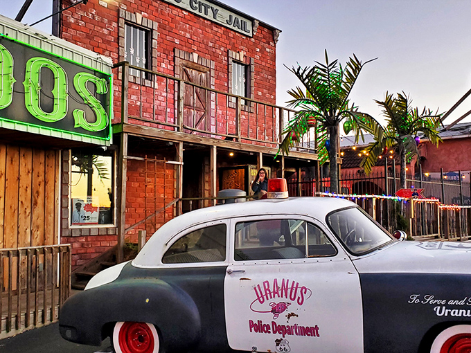 The "Uranus City Jail" facade perfectly captures the attraction's commitment to frontier-themed humor. Palm trees and hay bales create an unexpected Missouri oasis of quirky roadside charm.