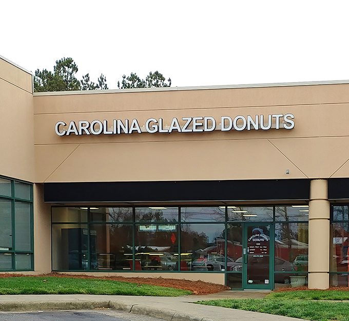 The unassuming storefront holds sweet treasures within. Like finding a $20 bill in old jeans, Carolina Glazed Donuts delivers unexpected joy. 