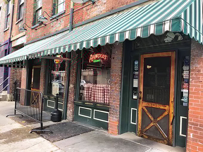 The unassuming exterior of Arnold's Bar & Grill beckons with its vintage charm and green-striped awning—Cincinnati's worst-kept secret hiding in plain sight.