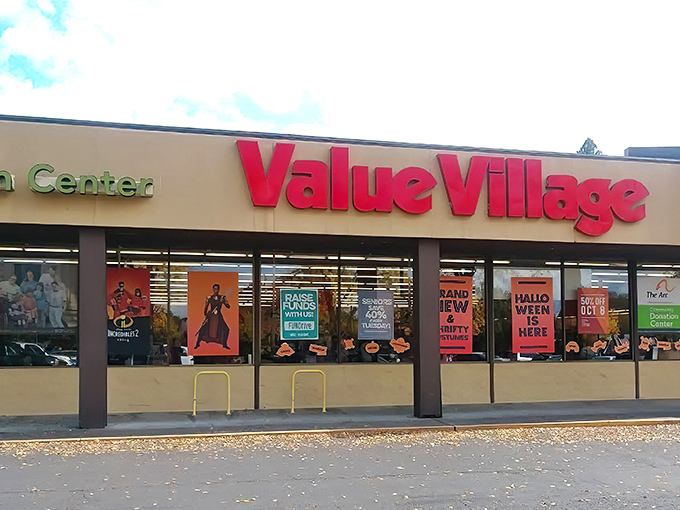 The iconic red Value Village sign beckons like a lighthouse for bargain hunters navigating the sea of retail sameness.