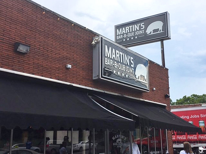 The red brick exterior of Martin's Bar-B-Que Joint beckons hungry pilgrims with its no-nonsense façade and the promise of smoky delights within.