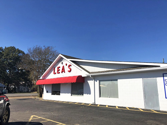 The iconic white building with bold red "LEA'S" lettering and matching awning stands as a beacon for hungry travelers – a Louisiana landmark since 1928.