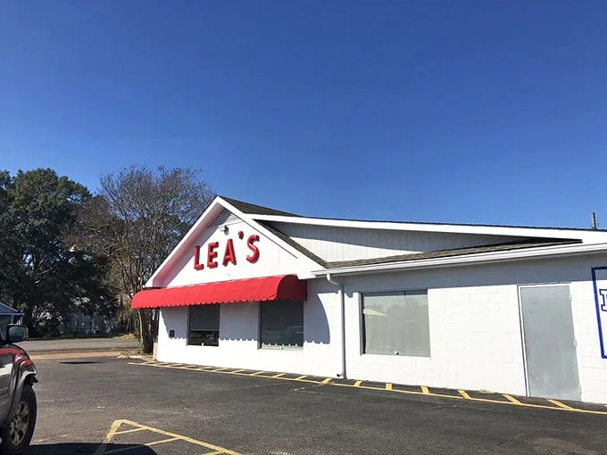 The iconic white building with bold red "LEA'S" lettering and matching awning stands as a beacon for hungry travelers – a Louisiana landmark since 1928.