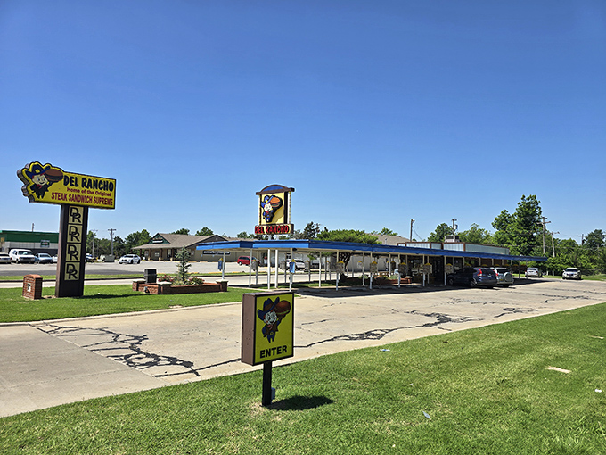 The classic drive-in canopy stands like a time portal to 1956, promising comfort food treasures beneath its nostalgic blue trim.