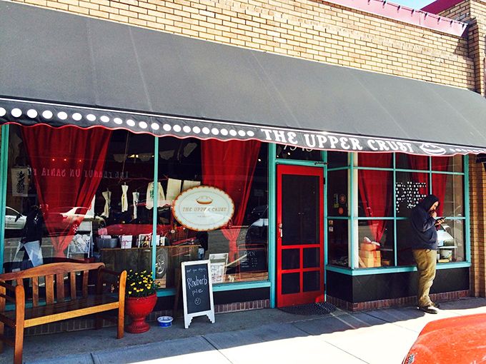 The unassuming storefront of The Upper Crust hides culinary treasures that would make any dessert detective's career. The black awning and brick façade promise old-school authenticity.