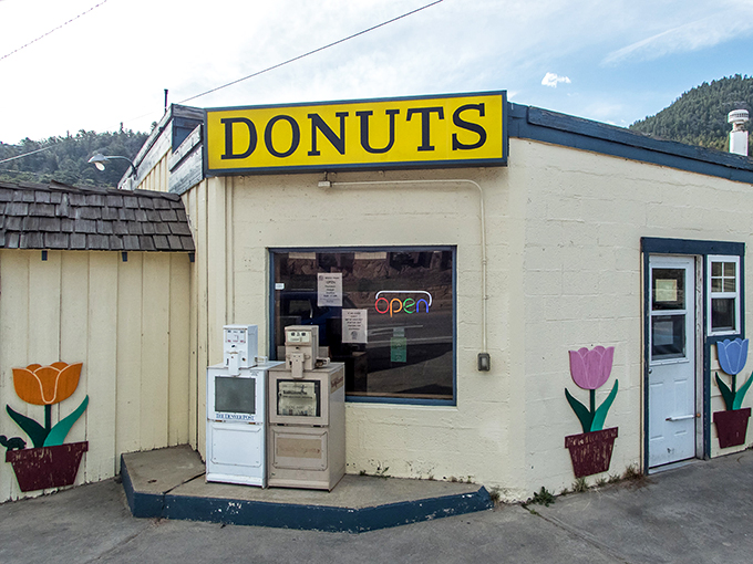 The unassuming exterior of Donut Haus stands like a beacon of sugary hope against the majestic Rocky Mountain backdrop. Sweet treasures await inside.