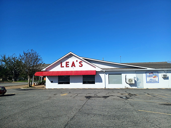 The iconic white building with bold red "LEA'S" lettering and matching awning stands as a beacon for hungry travelers – a Louisiana landmark since 1928.