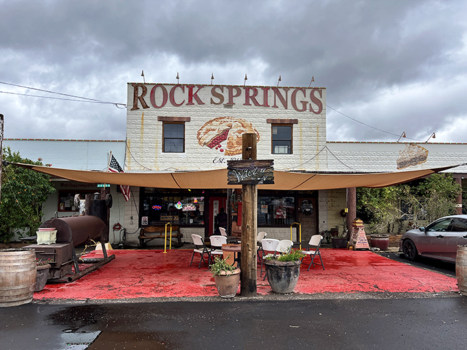 The iconic white facade of Rock Springs Café stands proudly against the Arizona sky, with that painted pie slice practically winking at hungry travelers on I-17.
