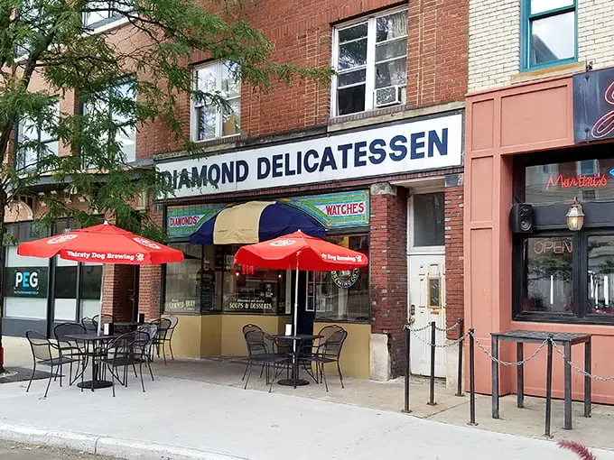The unassuming storefront of Diamond Deli beckons with its classic brick façade and cheerful red umbrellas—sandwich paradise hiding in plain sight.