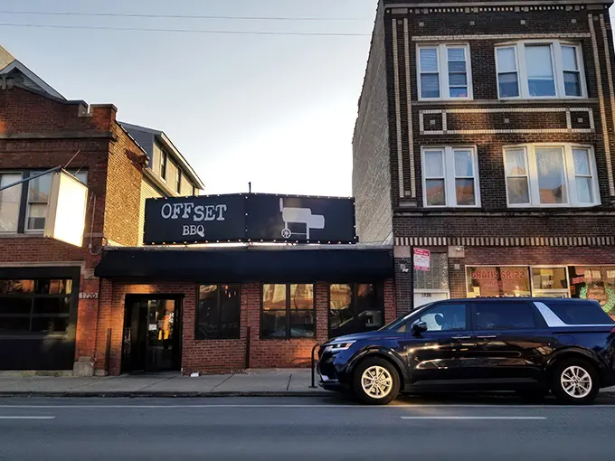 The glowing Offset BBQ sign beckons like a lighthouse for the hungry—Chicago's barbecue beacon against the twilight sky.