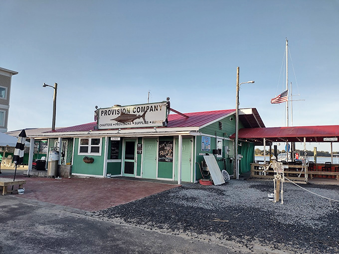 The unassuming entrance to seafood paradise – where that weathered fish sign promises more flavor than any fancy neon ever could. 
