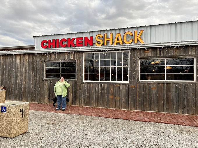 The humble wooden exterior of Chicken Shack stands proudly against an Oklahoma sky, its bold red and yellow sign promising poultry perfection inside.
