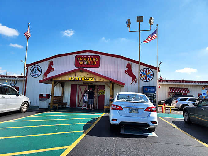 The iconic red and white entrance to Traders World beckons with its horse silhouettes and American flags—like the pearly gates of bargain heaven.