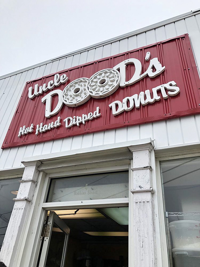 The iconic red and white sign promises "Hot. Hand. Dipped. Donuts." — four words that might be the sweetest poetry ever written on a storefront.