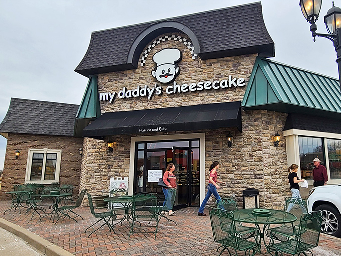 The charming stone facade of My Daddy's Cheesecake welcomes visitors with cheerful green umbrellas and outdoor seating - an irresistible invitation to dessert paradise. 