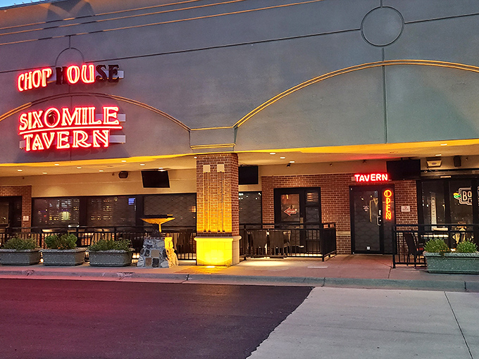 The neon sign of Six Mile Chop House beckons like a carnivore's lighthouse, promising safe harbor for the steak-obsessed traveler in Lawrence.