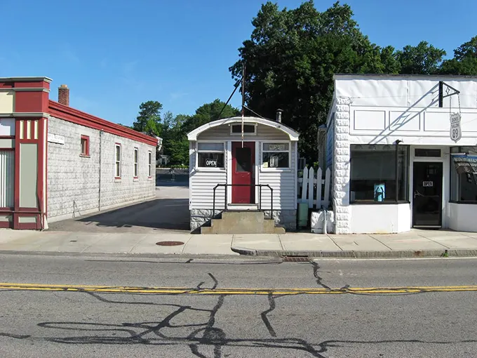 The unassuming white exterior with that pop of red door is like finding a treasure map in your attic—modest packaging, extraordinary reward inside.