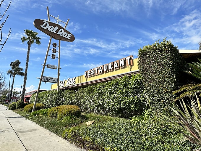 The neon sign beckons like a lighthouse for hungry souls. Palm trees and classic cars complete this quintessential Southern California supper club scene.