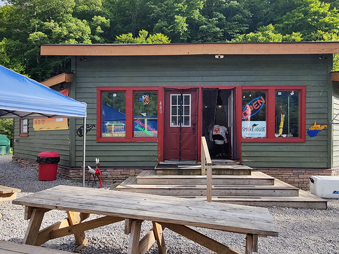 The green cabin nestled against West Virginia's lush forest backdrop isn't just a smokehouse—it's a portal to flavor country. Picnic tables await your food coma.