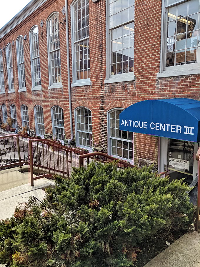The historic brick exterior of Savage Mill welcomes treasure hunters with its distinctive blue awning—industrial architecture transformed into an antiquing paradise.