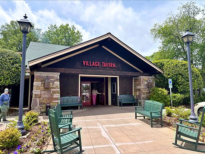 The rustic stone façade and welcoming teal benches at Village Tavern's entrance promise comfort before you even cross the threshold. 
