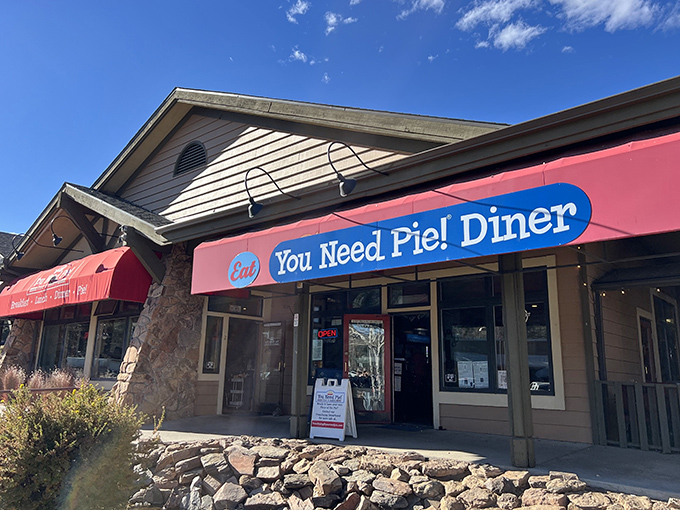 The bright red awning of You Need Pie! Diner isn't just inviting—it's making a bold statement about your immediate dietary requirements.