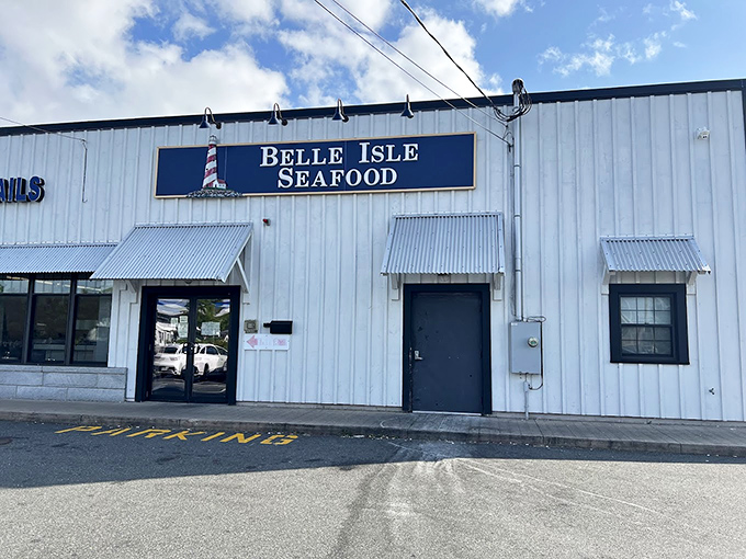The unassuming exterior of seafood paradise – where luxury cars and work trucks share parking spaces in democratic pursuit of lobster perfection.