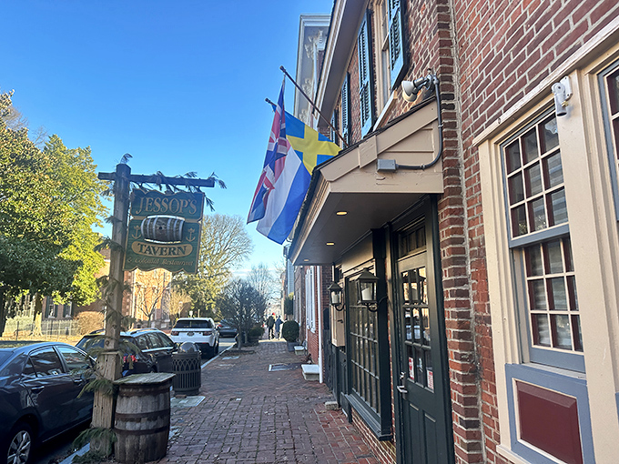 The historic façade of Jessop's Tavern welcomes you with colonial charm, international flags, and that wooden barrel that practically whispers, "Good times await inside."