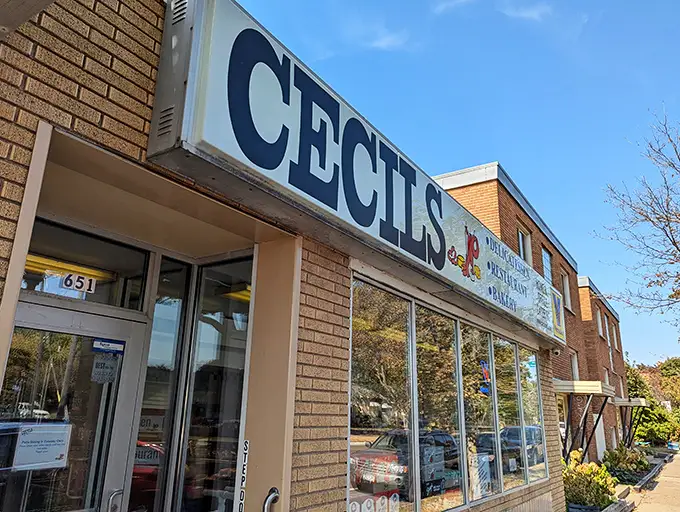 Welcome to Cecil's, where the neon sign promises delicatessen delights and the brick facade holds decades of delicious secrets!