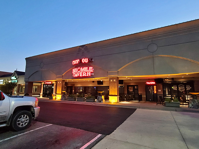 The neon sign of Six Mile Chop House beckons like a carnivore's lighthouse, promising safe harbor for the steak-obsessed traveler in Lawrence.
