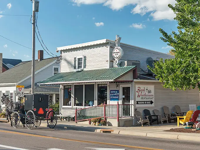 The unassuming white clapboard exterior of Boyd & Wurthmann stands like a time capsule on Berlin's main street, complete with that inviting green bench where friendships begin.