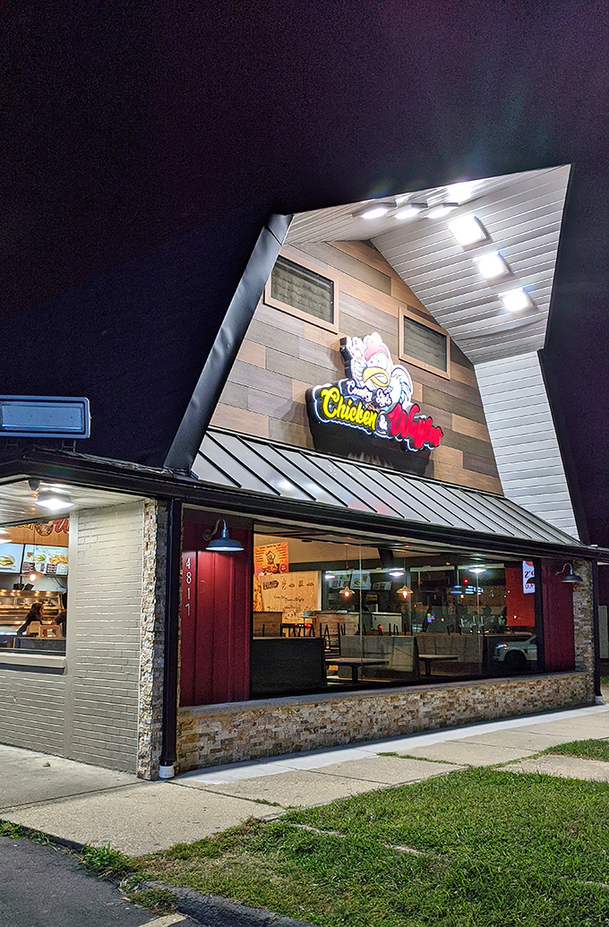 The distinctive peaked roof and illuminated sign of Country Style Chicken And Waffles beckons hungry travelers like a lighthouse for comfort food enthusiasts.