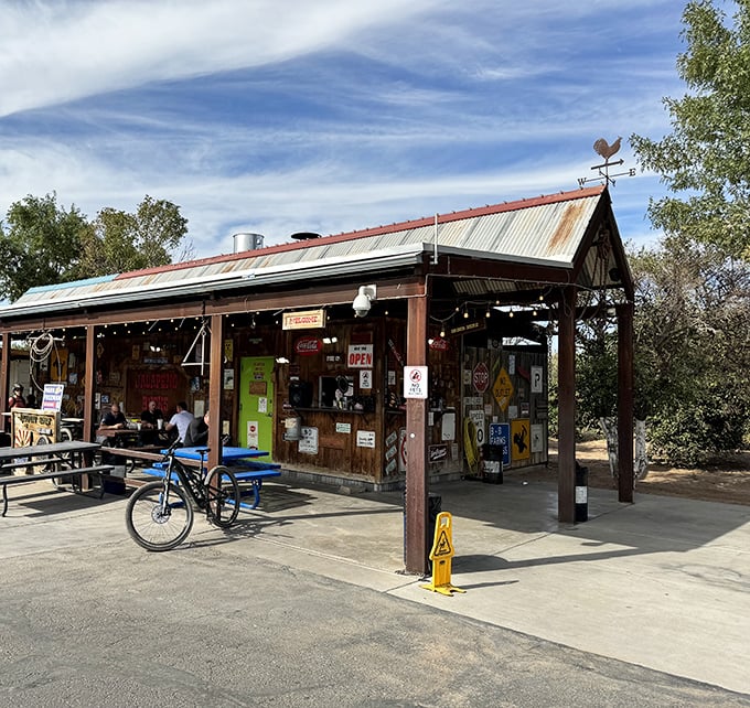 The rustic roadside charm of Jalapeño Buck's beckons hungry travelers with its weathered metal roof and promise of smoky delights ahead.