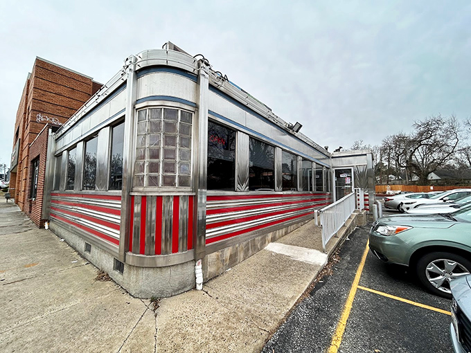 The gleaming stainless steel exterior of Overlea Diner shines like a time machine to the 1950s, complete with those iconic red stripes that practically scream "Come eat with us!"