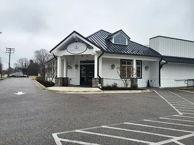 The white farmhouse exterior promises culinary magic within, like finding a surprise gift wrapped in architectural charm.