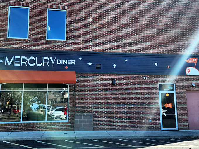 The Mercury Diner's navy blue facade with bright orange awning isn't just inviting—it's practically a bat signal for hungry Ohioans seeking comfort food nirvana.