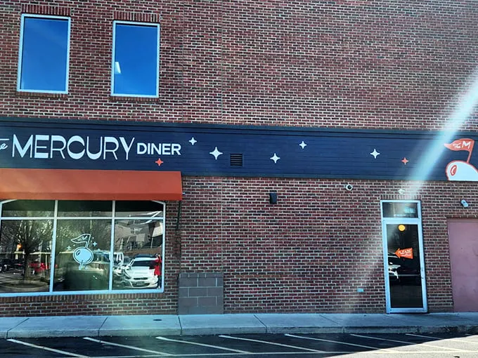 The Mercury Diner's navy blue facade with bright orange awning isn't just inviting—it's practically a bat signal for hungry Ohioans seeking comfort food nirvana.