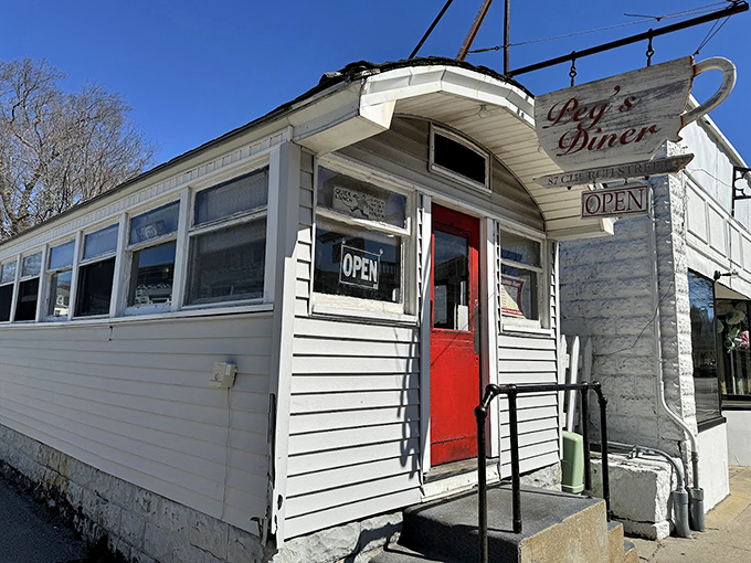 The unassuming white exterior with that pop of red door is like finding a treasure map in your attic—modest packaging, extraordinary reward inside.