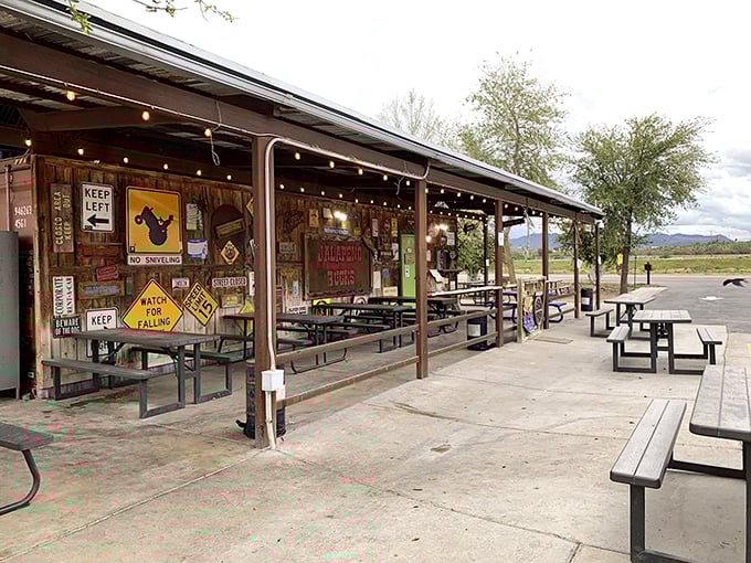 The rustic roadside charm of Jalapeño Buck's beckons hungry travelers with its weathered metal roof and promise of smoky delights ahead.
