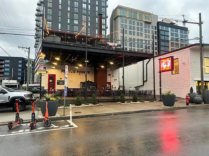 The glowing neon pig sign beckons hungry travelers like a barbecue lighthouse in Nashville's urban landscape.