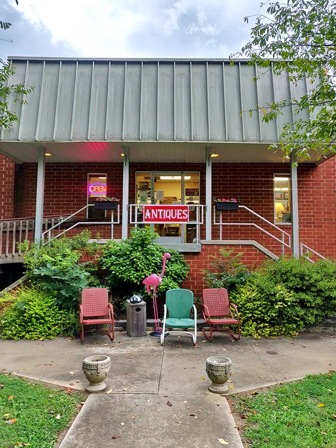 The unassuming brick façade with its vintage metal chairs and flamingo sentinel—proof that the best treasure maps often start with a simple "ANTIQUES" sign.