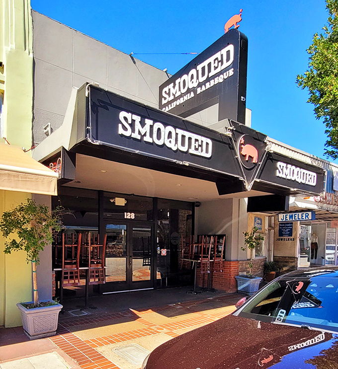The pink pig silhouette perched atop Smoqued's sign isn't just cute – it's a beacon of hope for BBQ lovers wandering the California desert of mediocre meat.