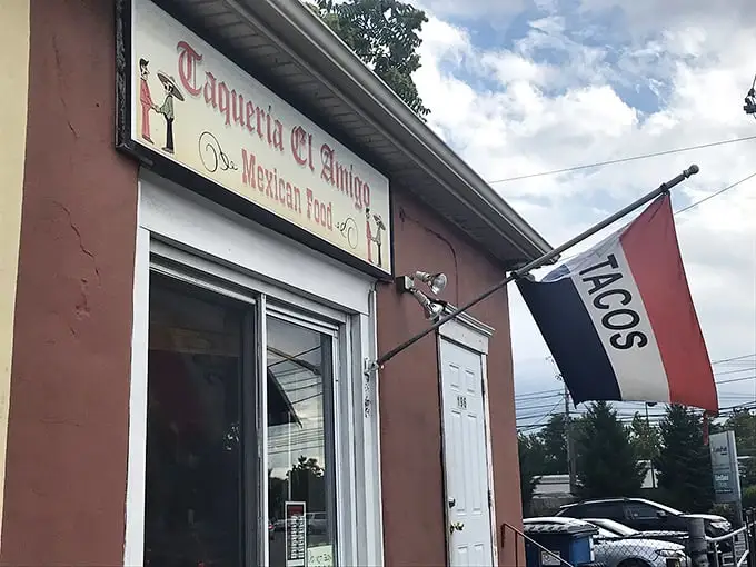 The unassuming exterior of Taqueria El Amigo might fool you, but that "TACOS" flag is actually the culinary equivalent of "Treasure Found Here!"