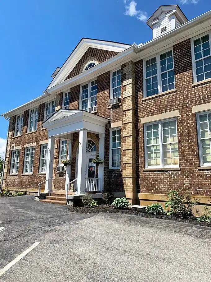 The stately brick exterior of Schoolhouse Fabrics stands as a testament to its educational past, now housing three floors of textile treasures.