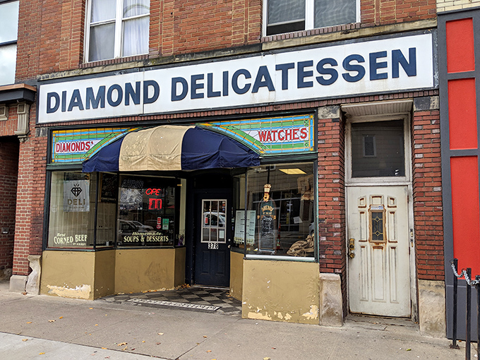 The unassuming storefront of Diamond Deli beckons with its classic brick façade and cheerful red umbrellas—sandwich paradise hiding in plain sight.