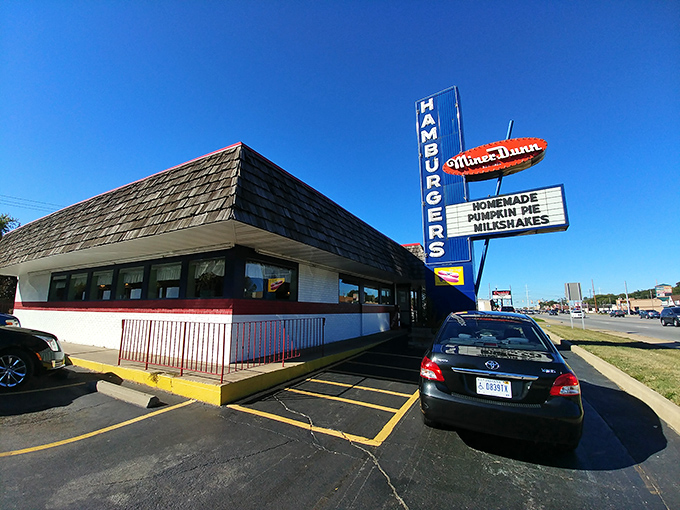 That classic blue "HAMBURGERS" sign isn't just roadside decor—it's a bat signal for those who appreciate the difference between fast food and food worth slowing down for.