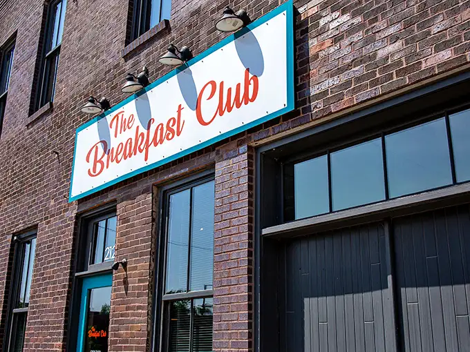 The turquoise-framed sign against rustic brick promises a breakfast revolution hiding behind that unassuming door at 212 East 3rd Street.
