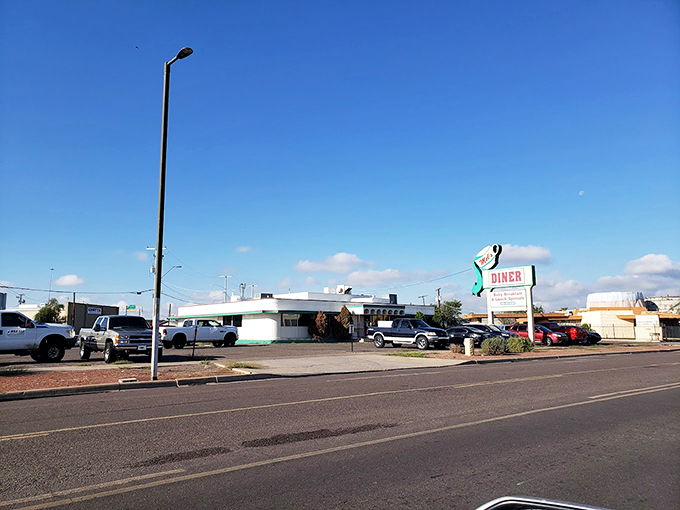 The classic roadside silhouette of Mel's Diner stands proudly against Arizona's impossibly blue sky, a time capsule of Americana waiting to welcome hungry travelers.