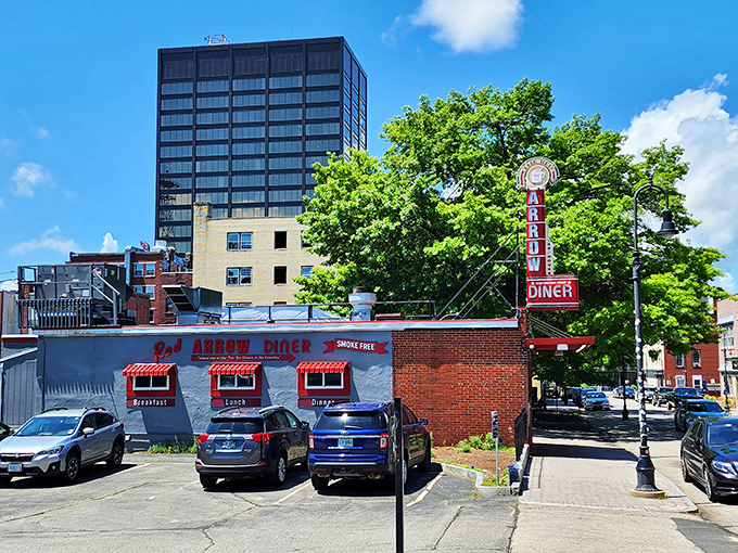 The iconic Red Arrow Diner storefront beckons hungry travelers with its vintage neon sign and promise of 24-hour comfort food. Manchester's brick-and-mortar time machine awaits.